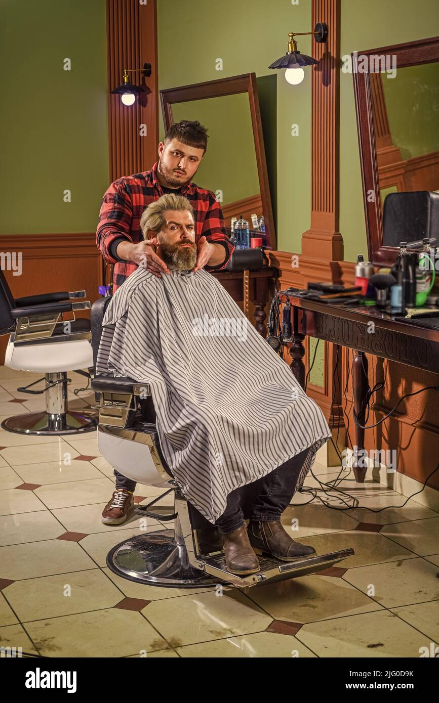 Time for new haircut. hipster man with beard cutting his hair in a ...