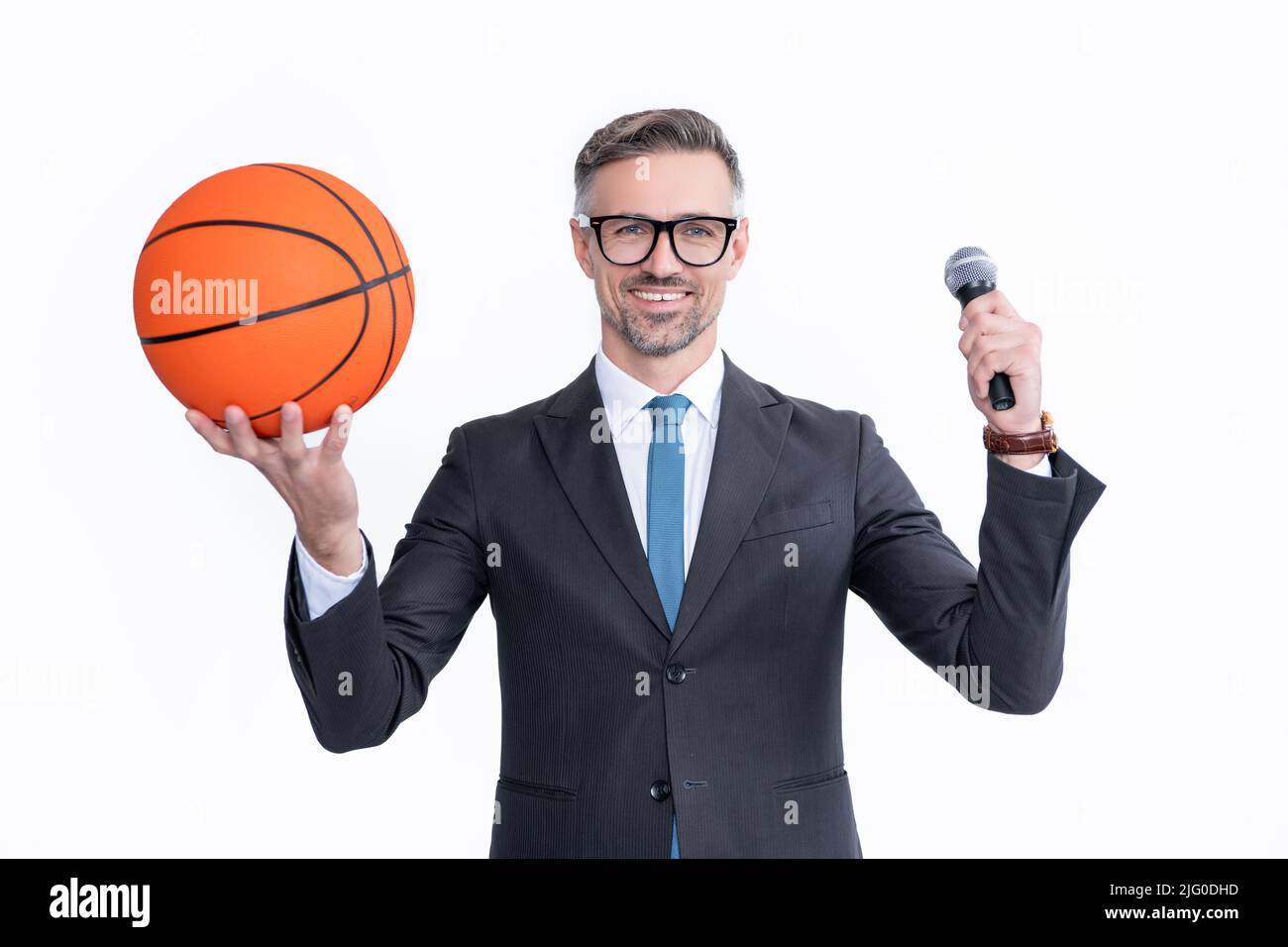 glad mature man in suit hold basketball ball and microphone isolated on ...
