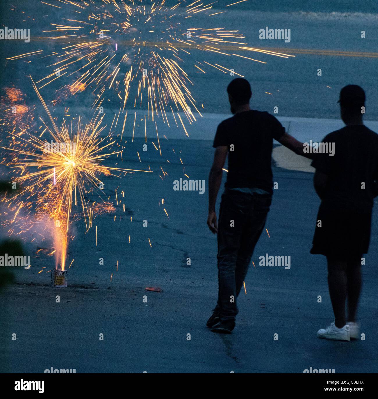 A view of two young men setting off fireworks in the street Stock Photo ...