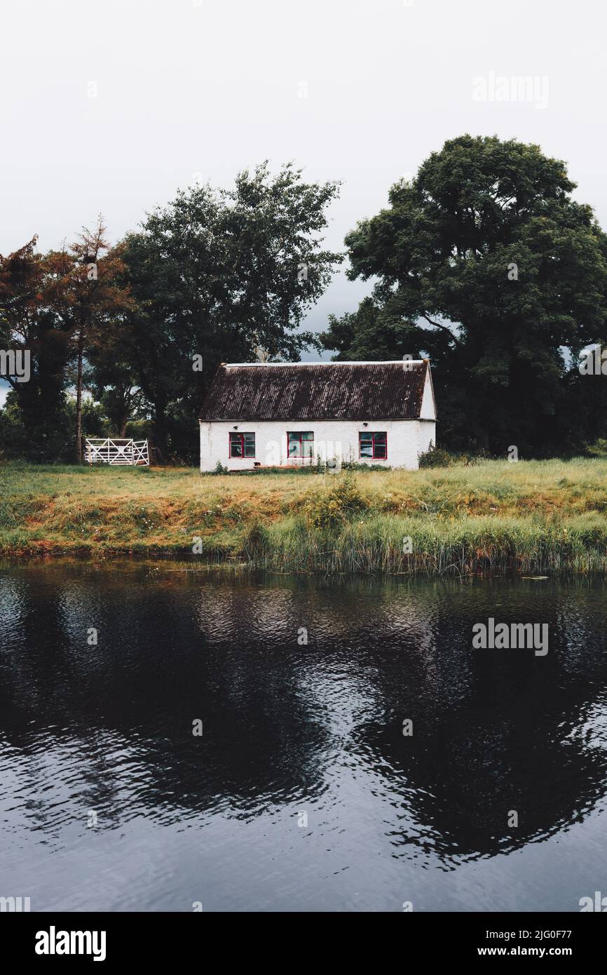 A small house on calm lake shore Stock Photo - Alamy