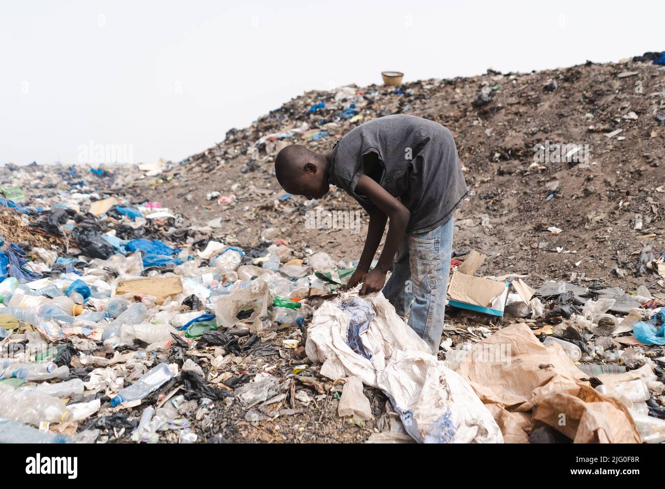 Black african boy filling garbage bag hi-res stock photography and ...