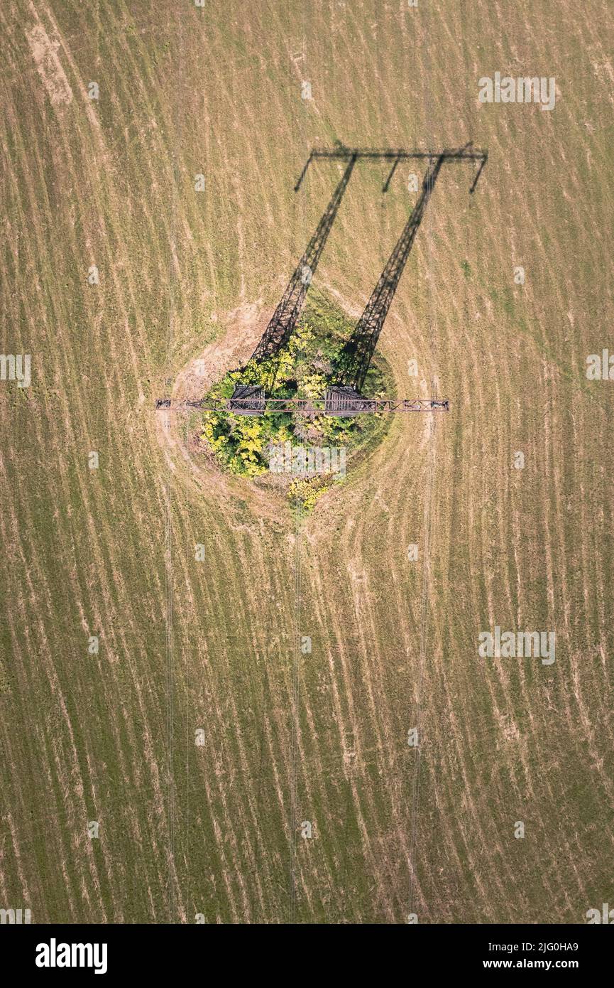 Powerline transmission tower alone on the mowed field Stock Photo - Alamy