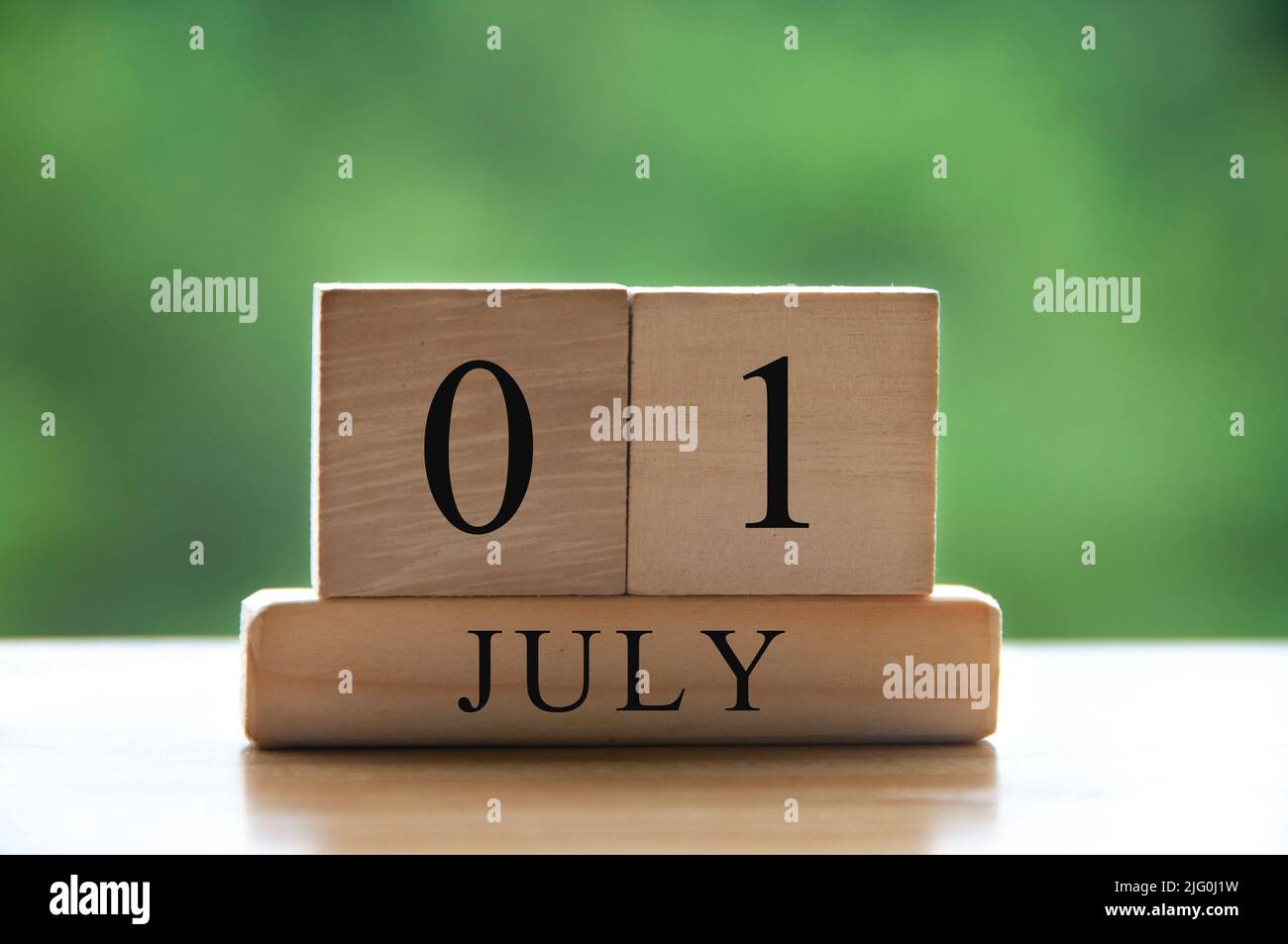 July 1 calendar date text on wooden blocks with blurred background park ...