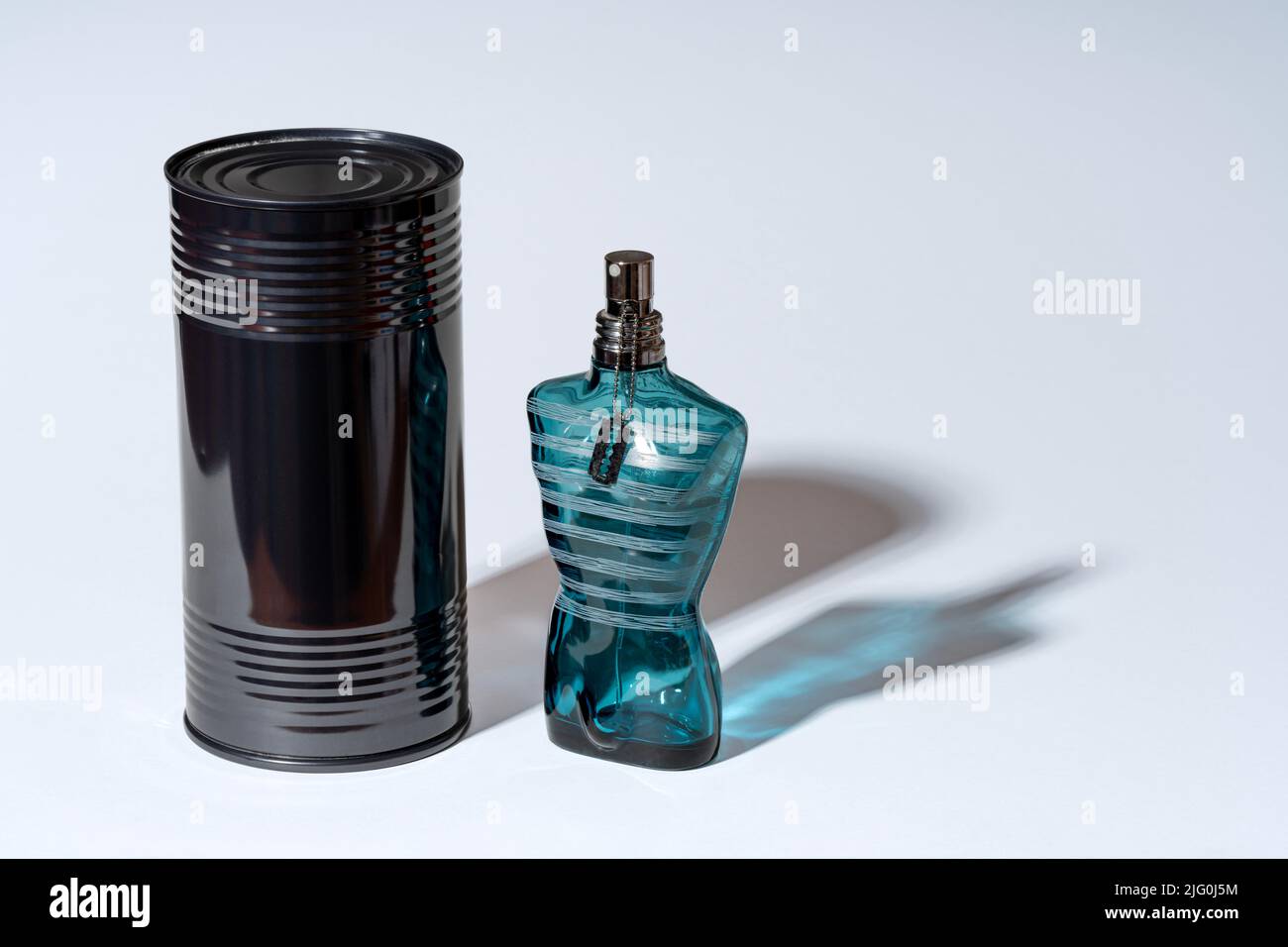 still life. Studio shot of a blue perfume bottle and its tin can ...