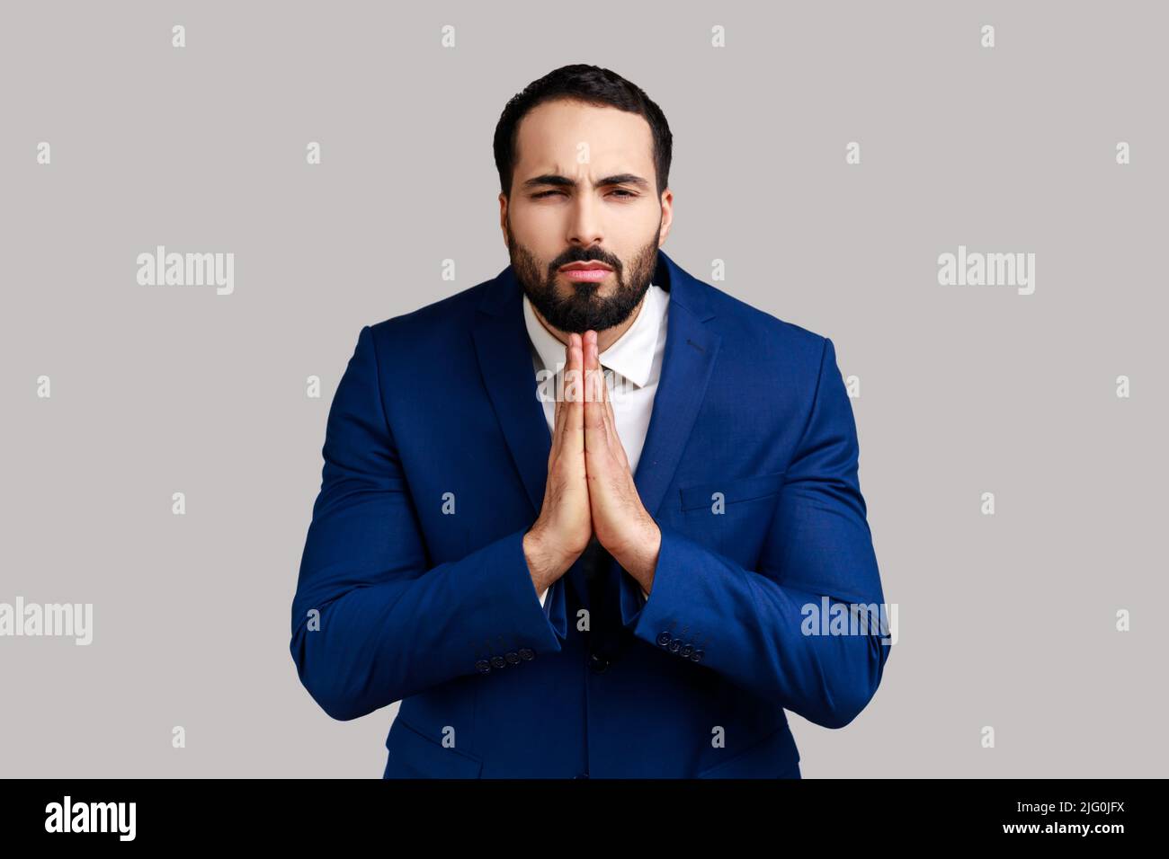 Portrait of man holding hands in prayer, looking with imploring ...
