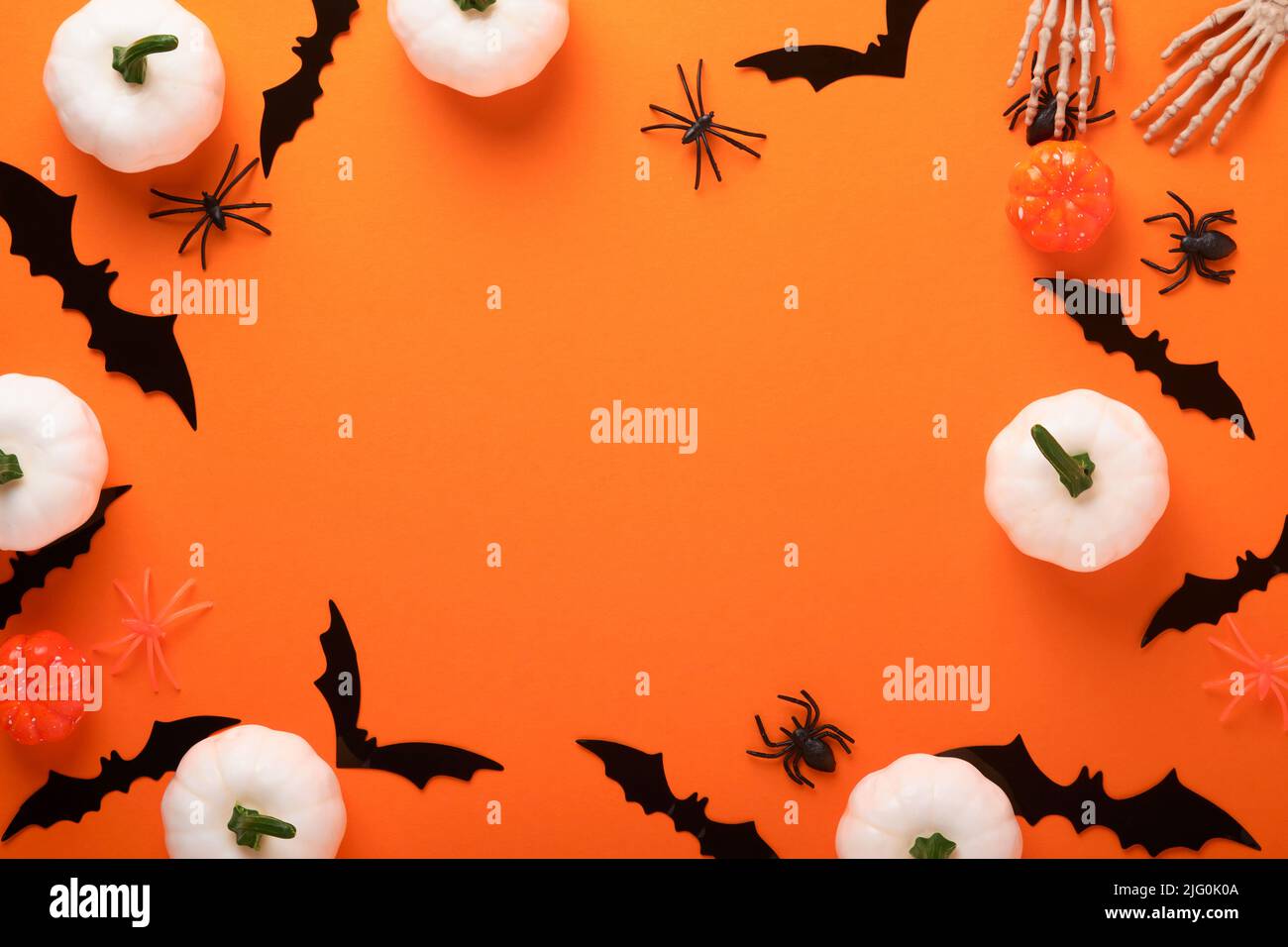 Orange Halloween background. Flock of black bats, spider, pumpkin ...