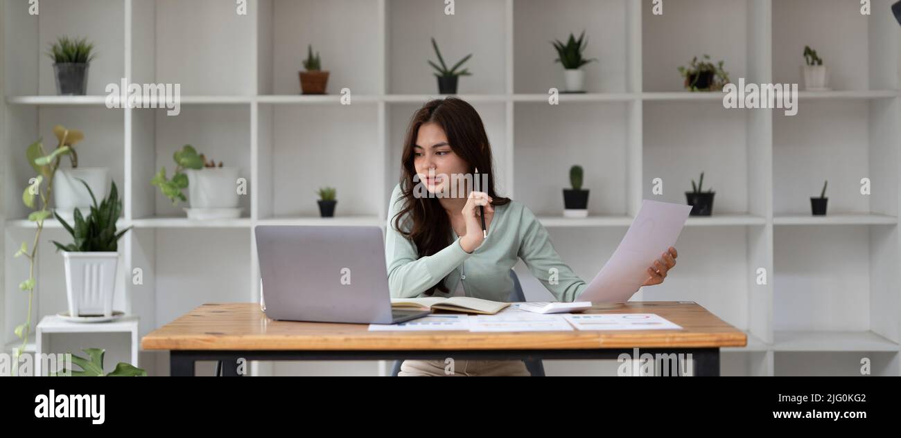 Portrait of businesswoman using laptop computer while working with ...