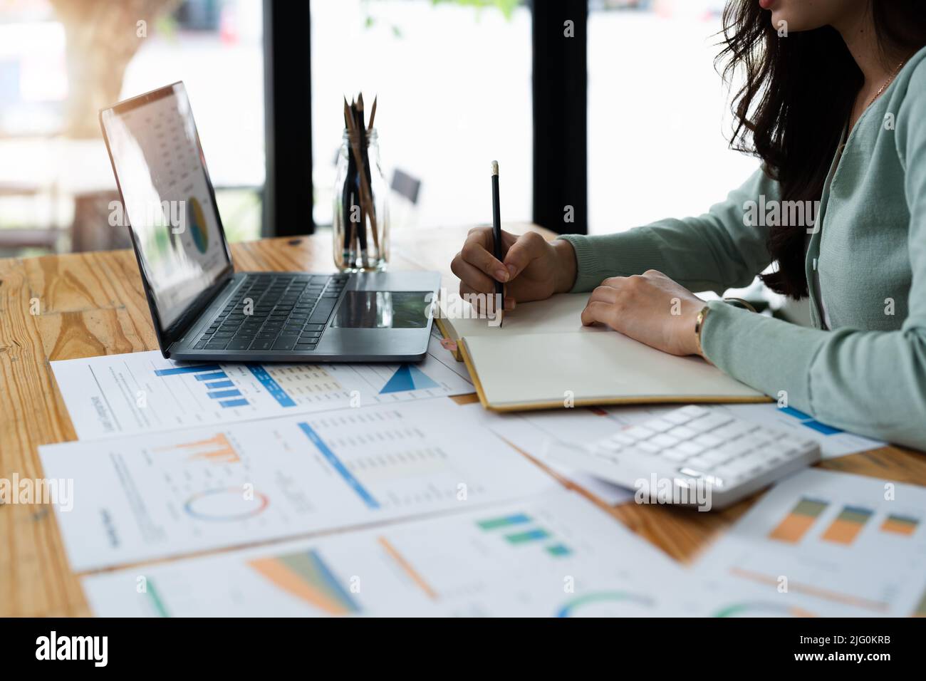 businesswoman or accountant taking note and working on calculator and ...