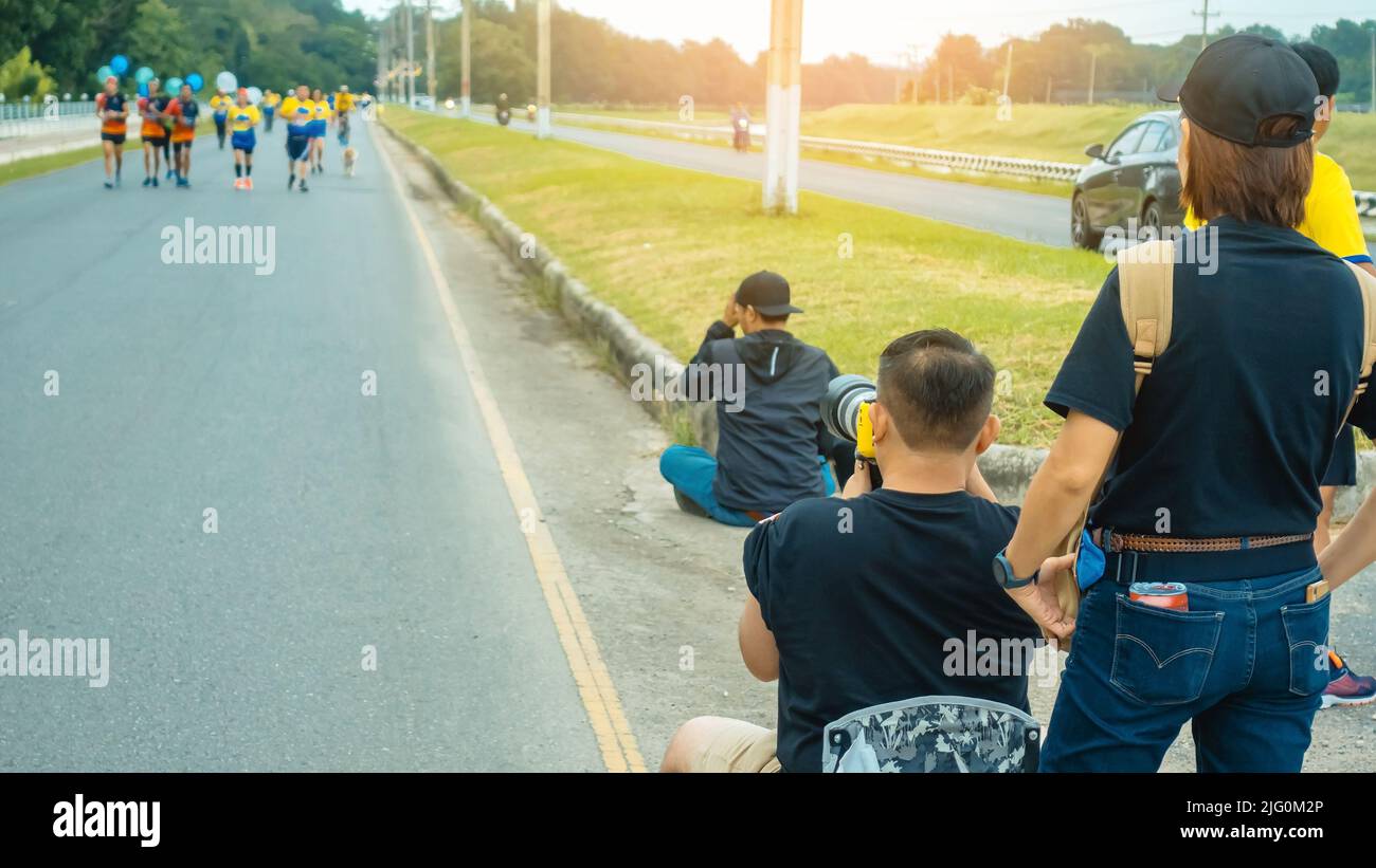 Back view of Asian sport photographer with camera sit to take picture ...