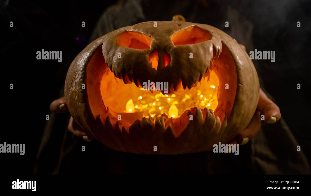 The witch is holding a pumpkin jack about a lantern glowing in the dark ...