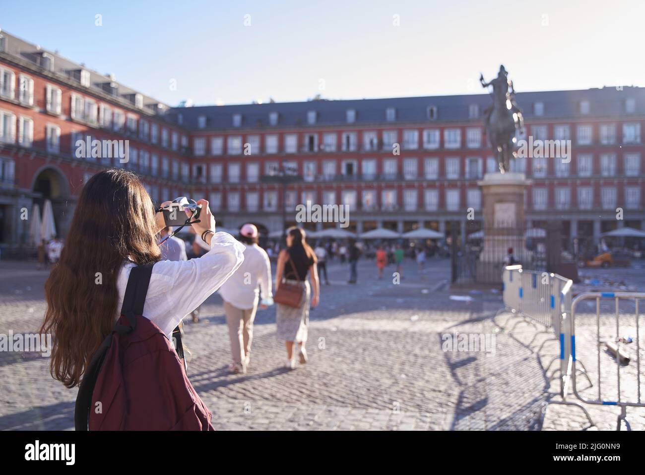 Young tourist holding a camera and taking a photo at Plaza Mayor ...