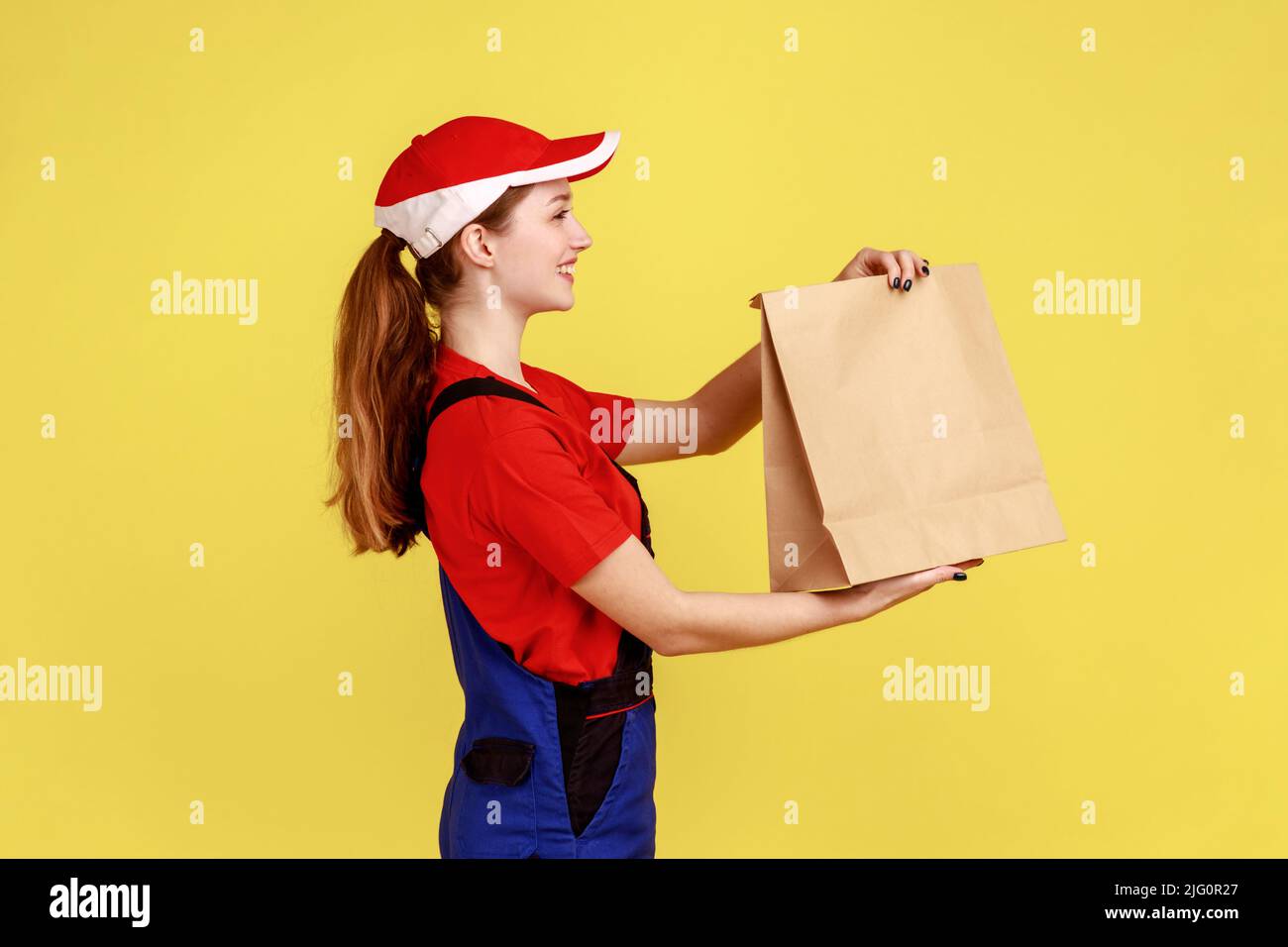 Side view portrait of courier woman giving paper parcel to client, fast ...