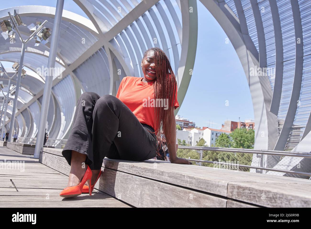 woman sits outside on a park bench, enjoying the fresh air. With a ...