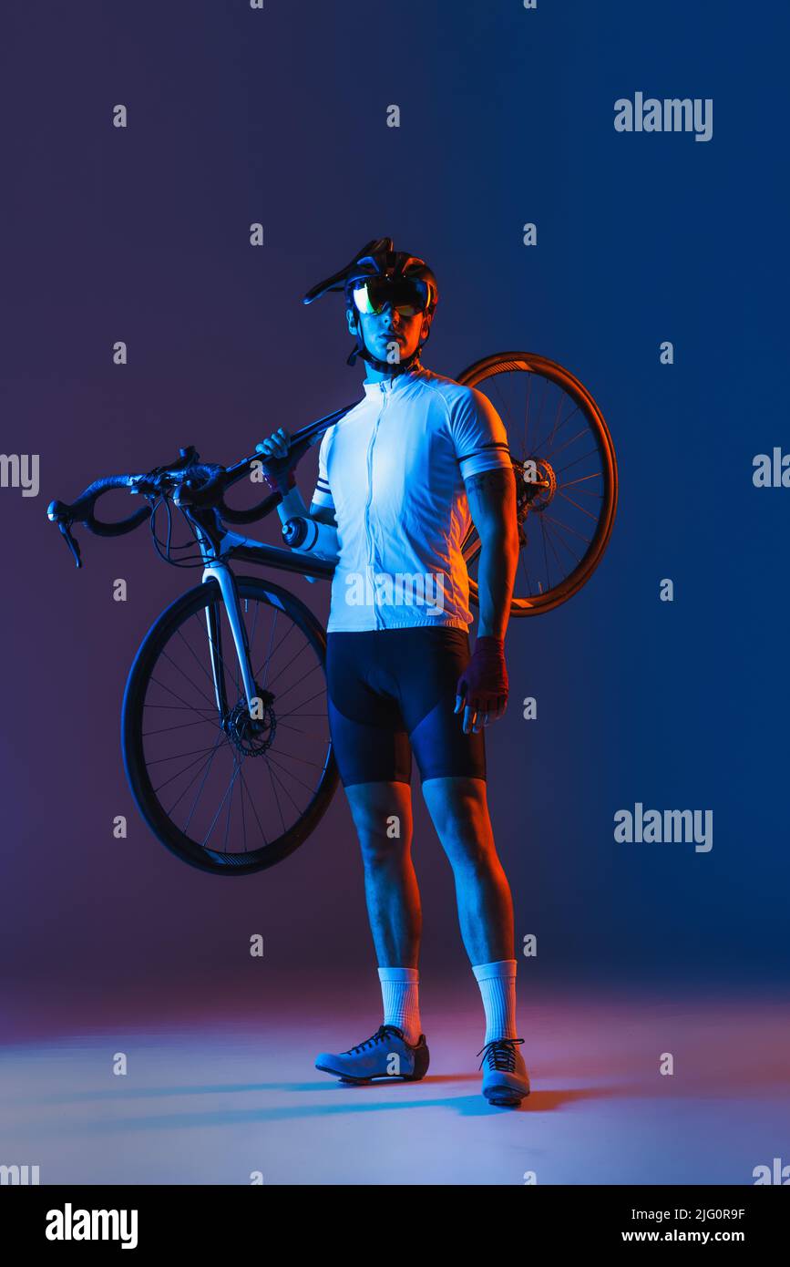 Portrait of professional cyclist in red sports uniform, goggles and ...