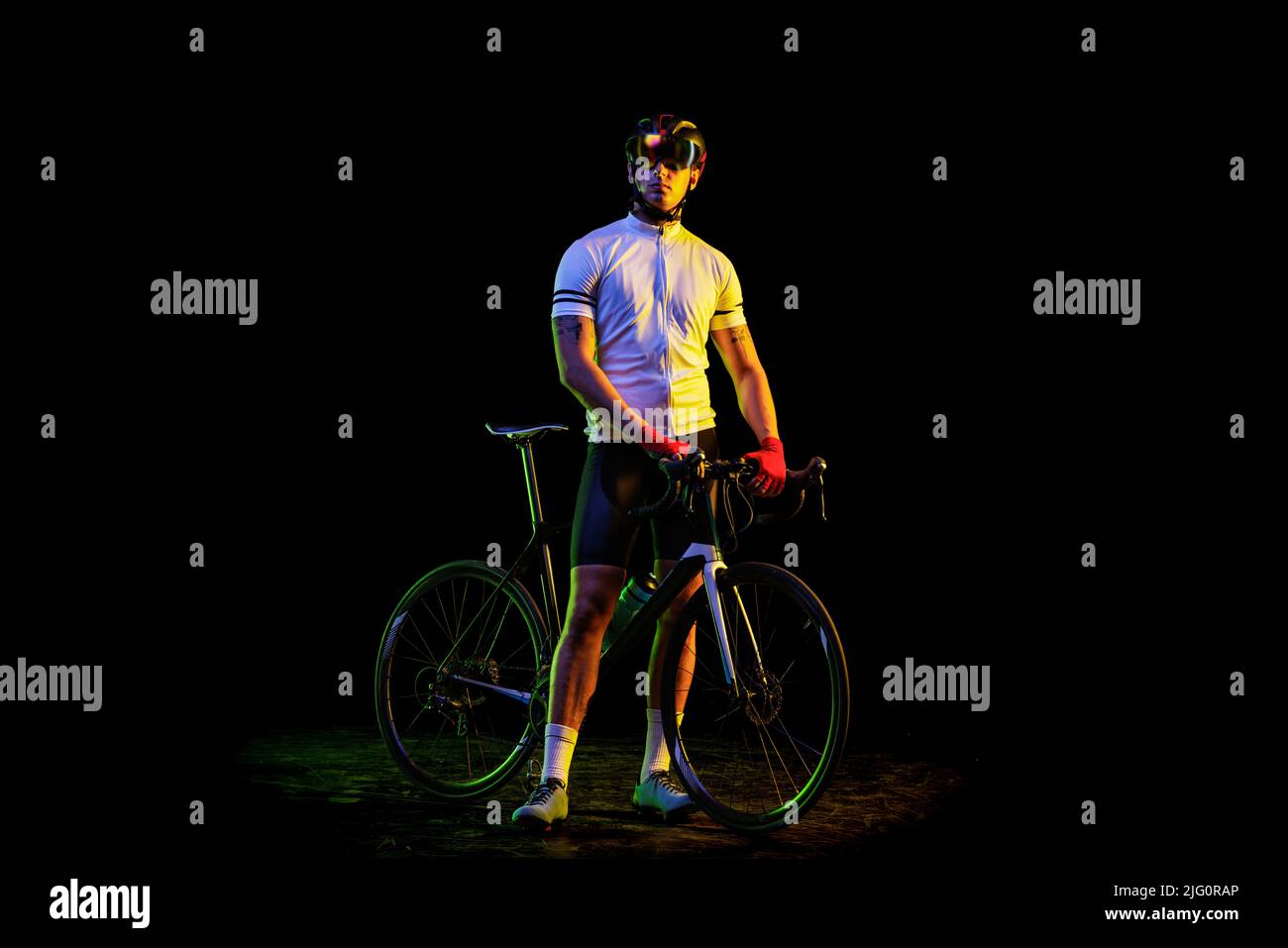 Full-length portrait of young male cyclist on bicycle in cycling shorts ...