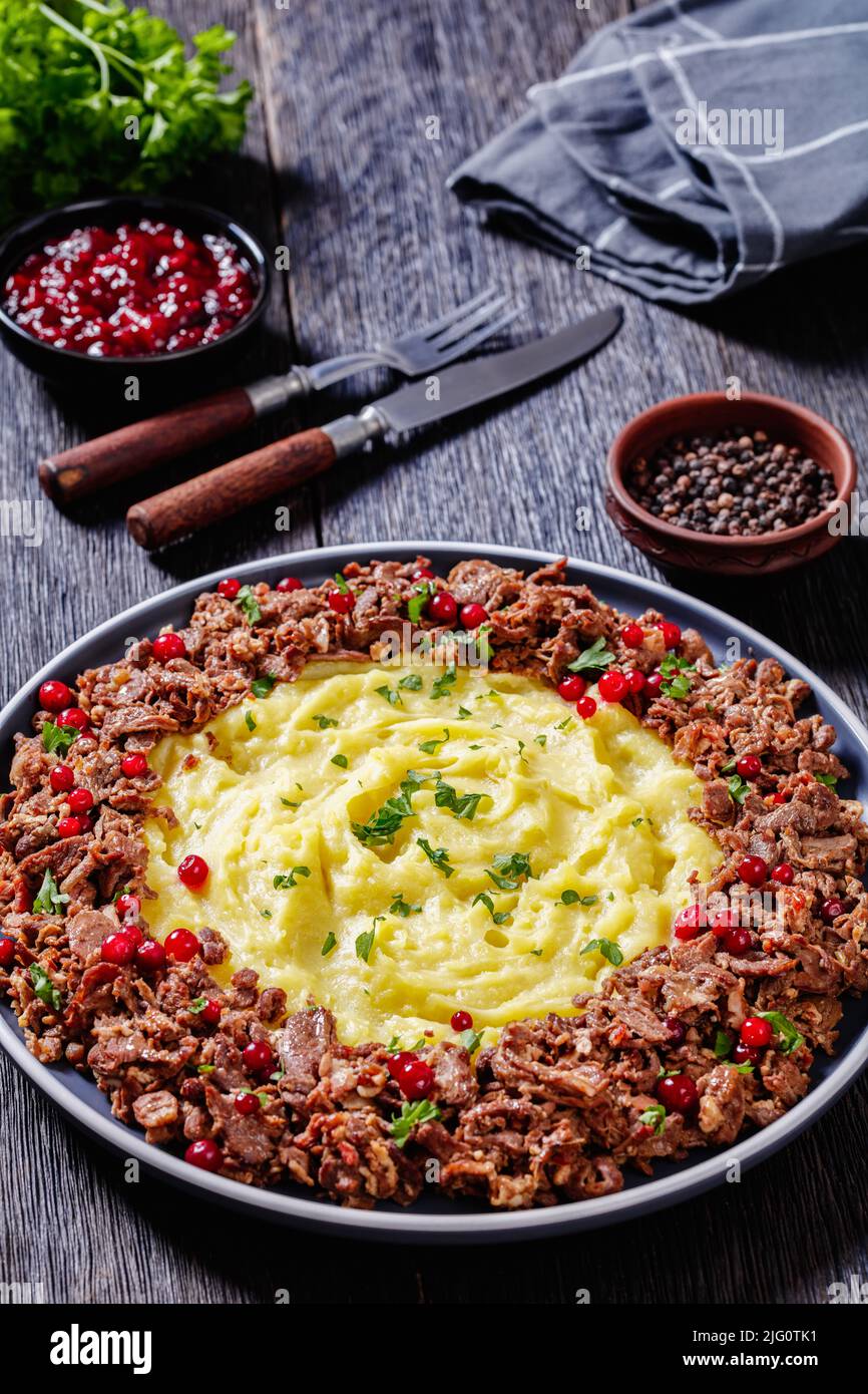 Reindeer Stew with Lingonberries and potato puree on plate on oak wood ...