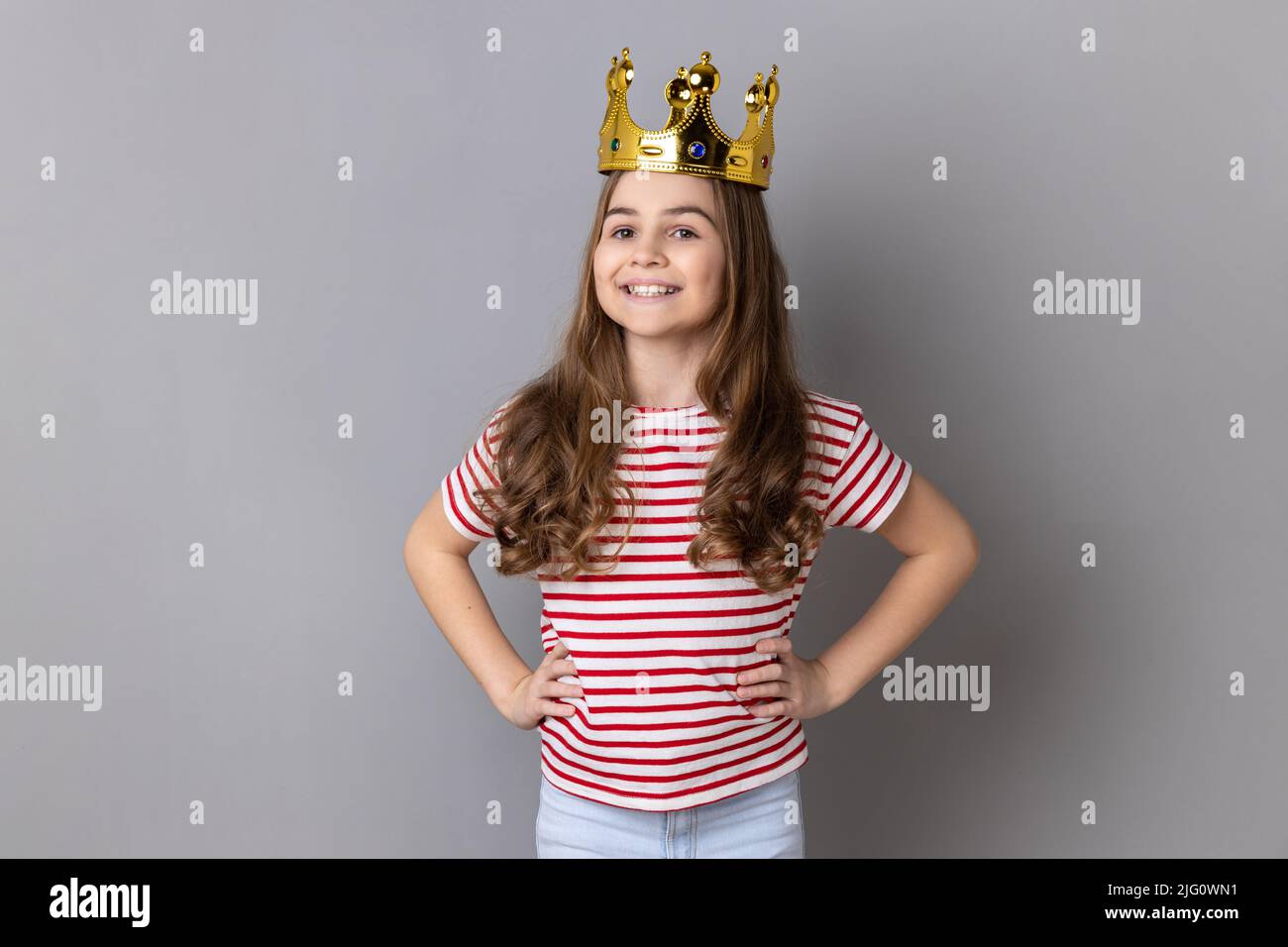 Portrait of satisfied arrogance little girl princess wearing striped T ...