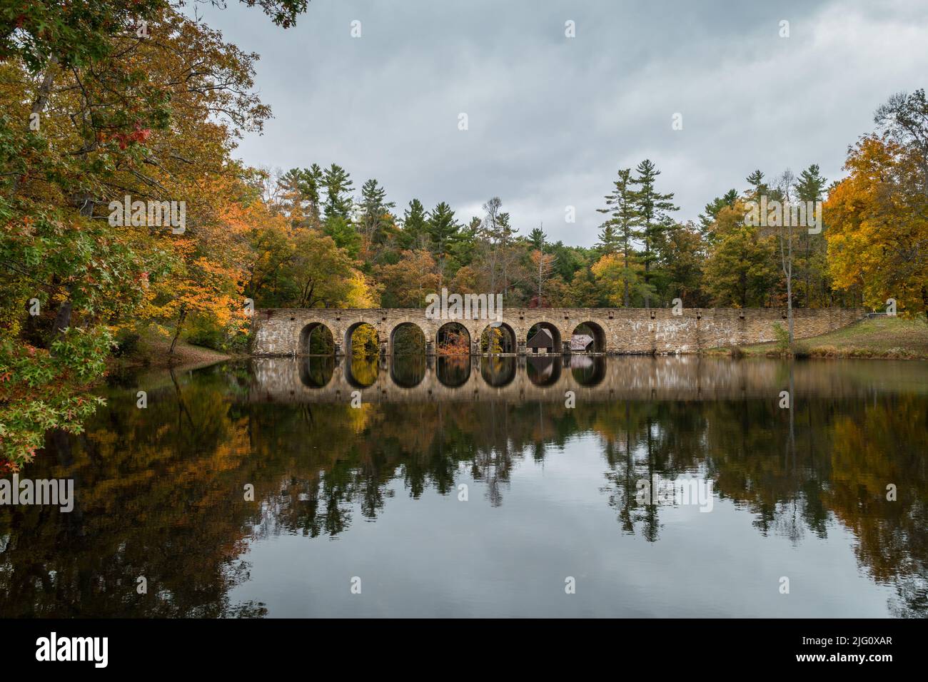 Seven arch bridge with the colorful trees in autumn in a still tranquil ...