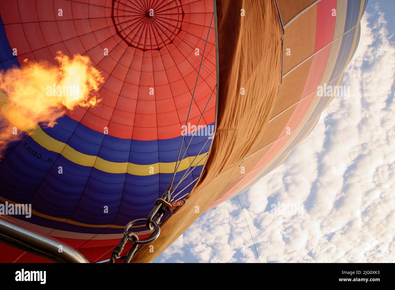 A hot air balloon. Orange flames fire into the balloon envelope to fill ...