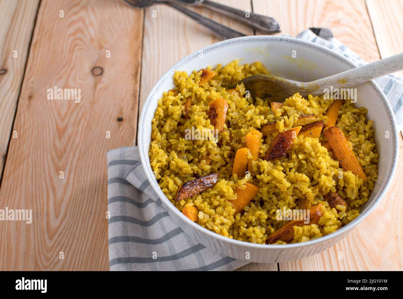 Healthy side dish with brown rice, turmeric and roasted carrots in a ...