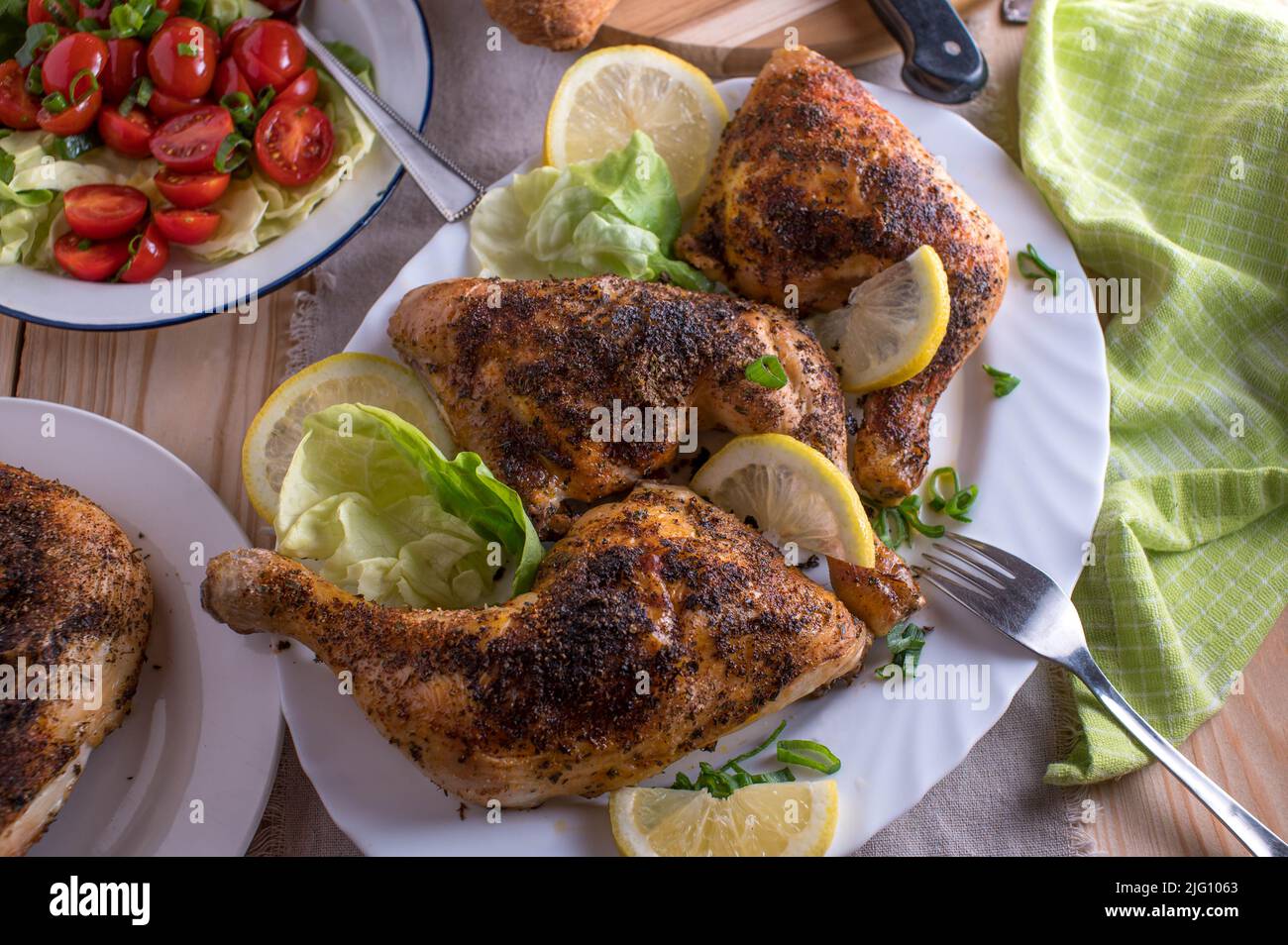Baked chicken legs with salad on a table. Healthy eating family dish ...