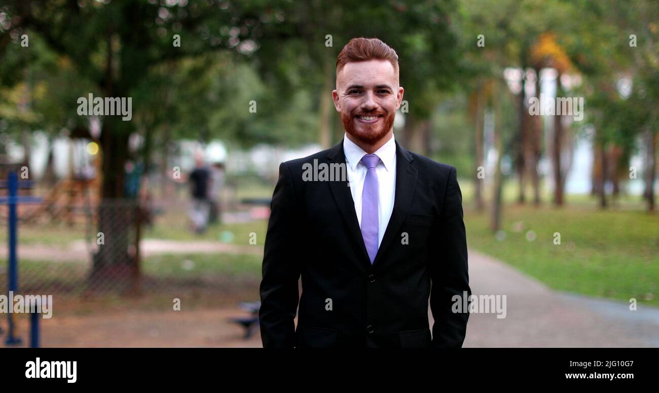 Man wearing suit standing outside at park, irish ginger executive ...