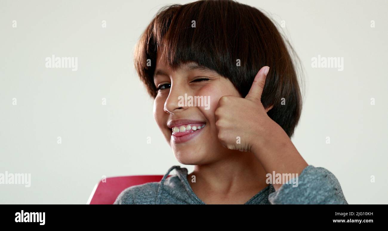 Mixed race child approving with hand giving thumbs up to camera Stock ...