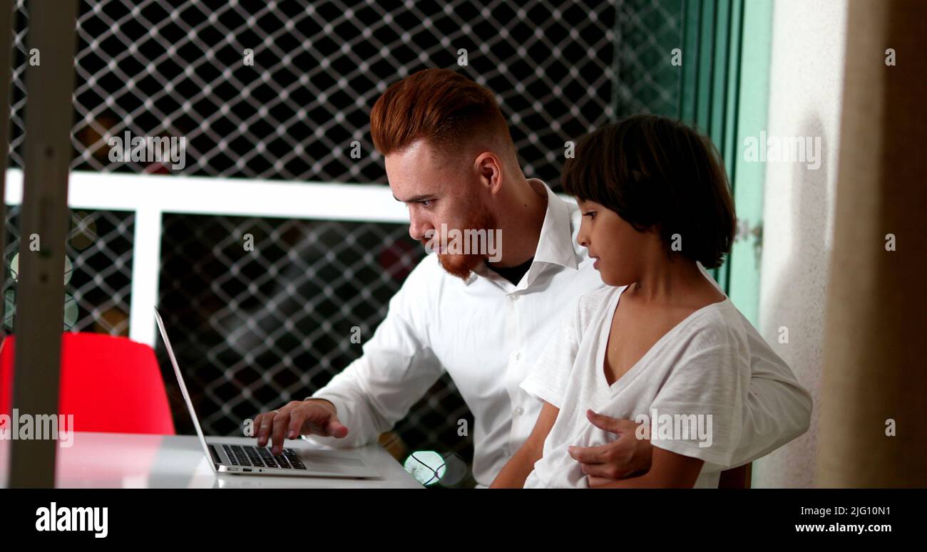 Parent and child bonding together in front of laptop computer. Ethnic ...
