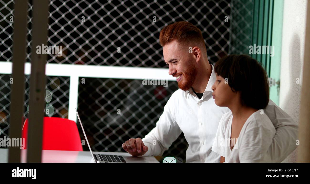 Parent and child bonding together in front of laptop computer. Ethnic ...