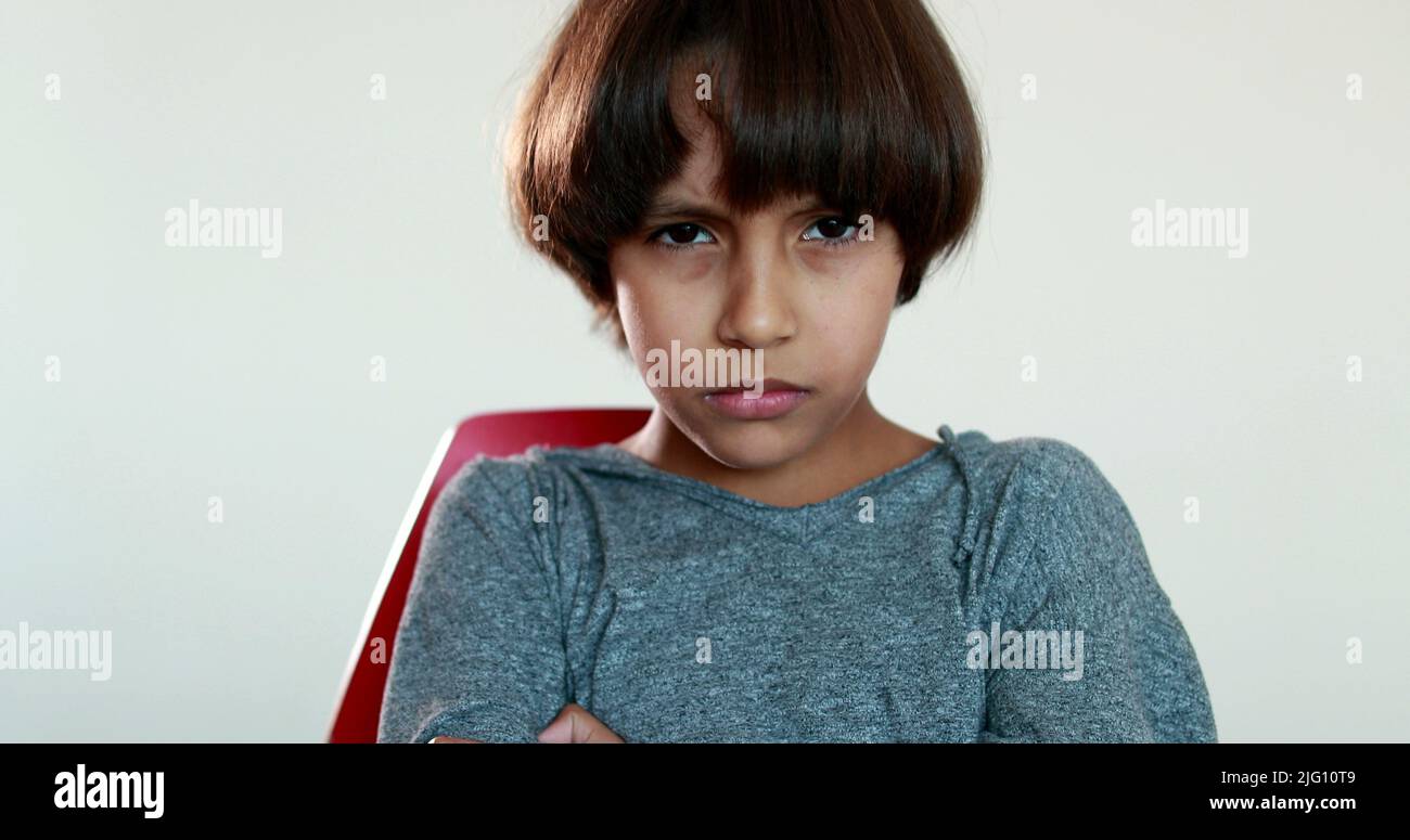 Pensive child changing mood becoming angry crossing arms Stock Photo ...