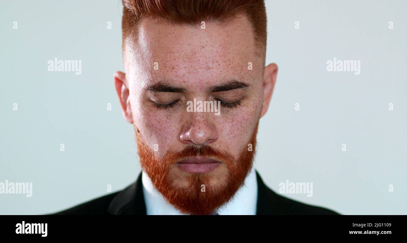 Pensive redhair man closin eyes in contemplation and meditation ...