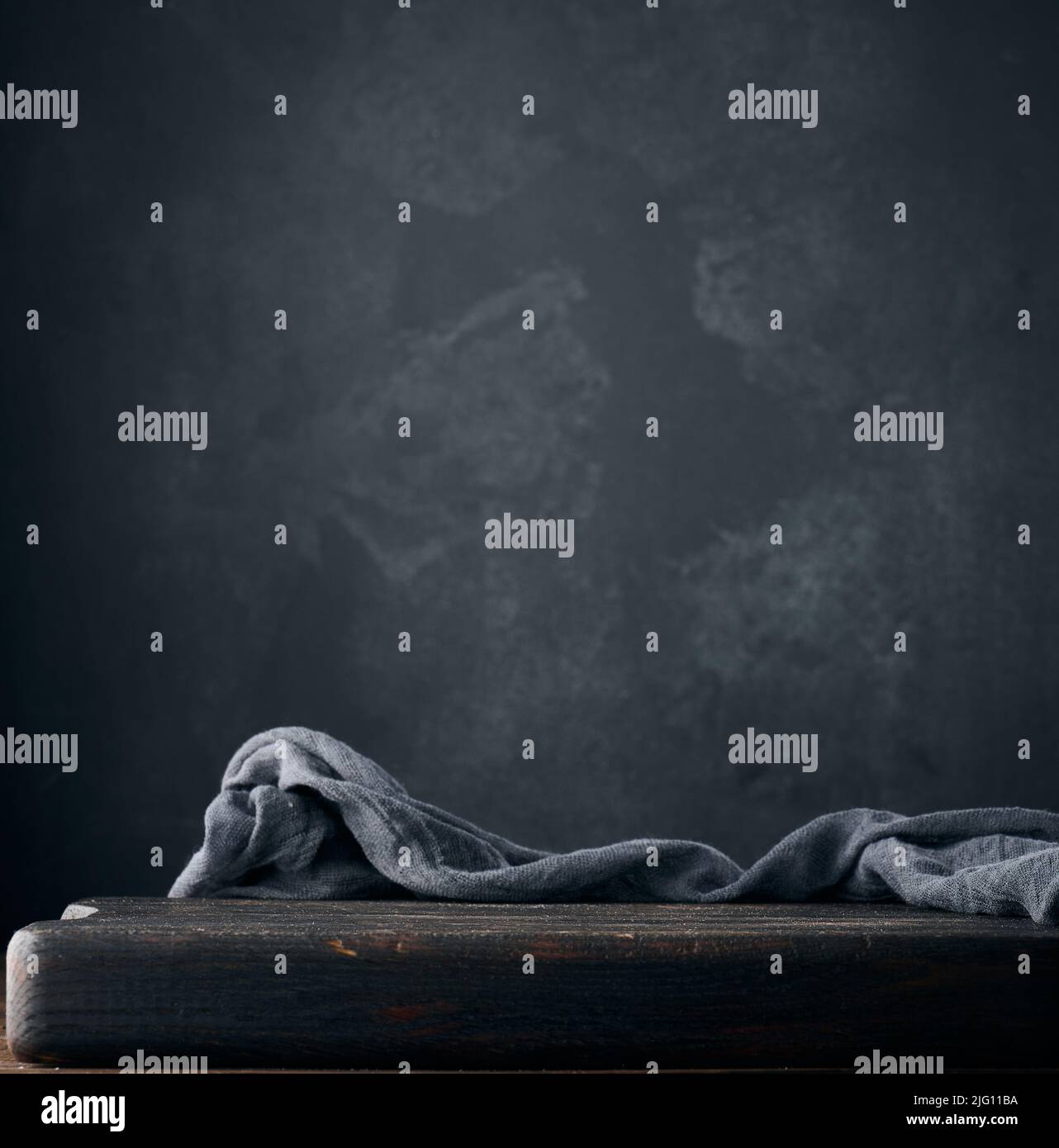 Black empty wooden square cutting board on black table, food display ...