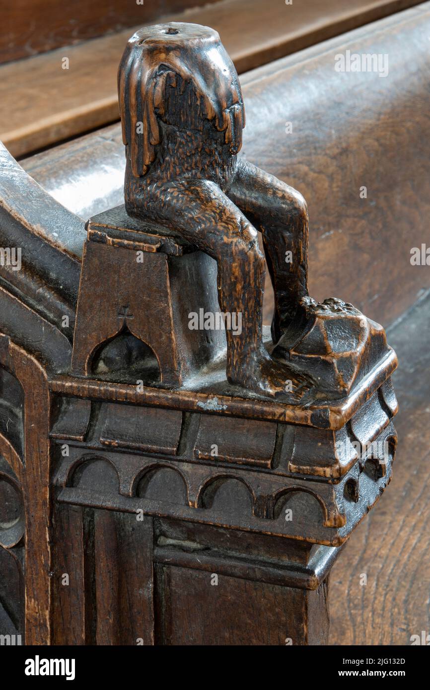 15th century wood carved bench end forming a seated headless male ...