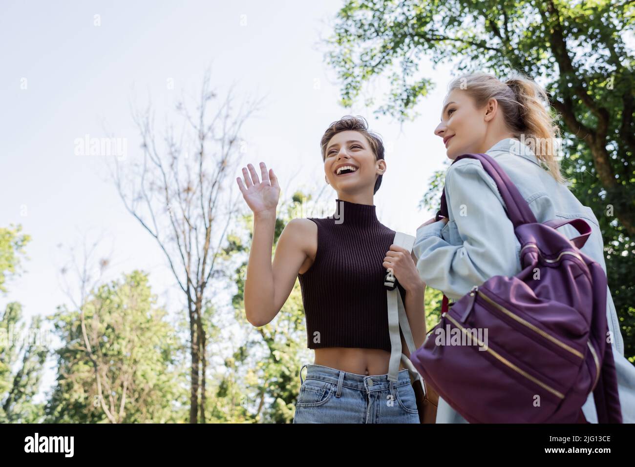 Group smiling students waving hi-res stock photography and images - Alamy