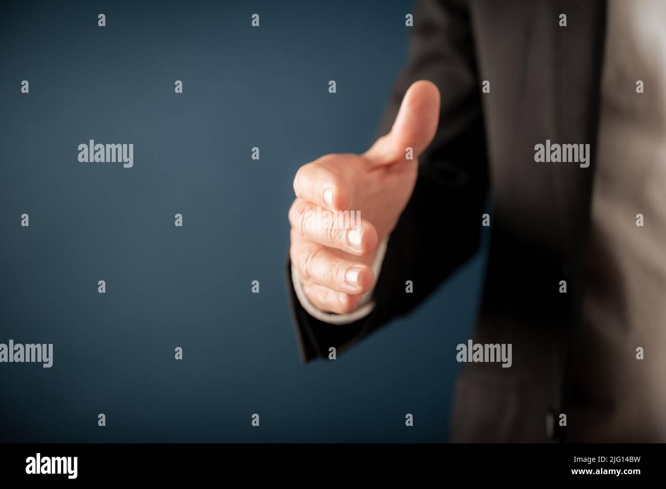 Closeup view of a businessman offering his hand in handshake or ...