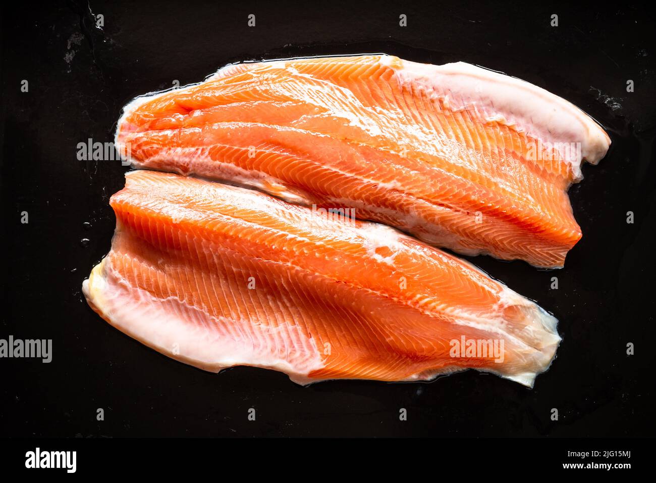 Fresh salmon fish at black top view Stock Photo - Alamy
