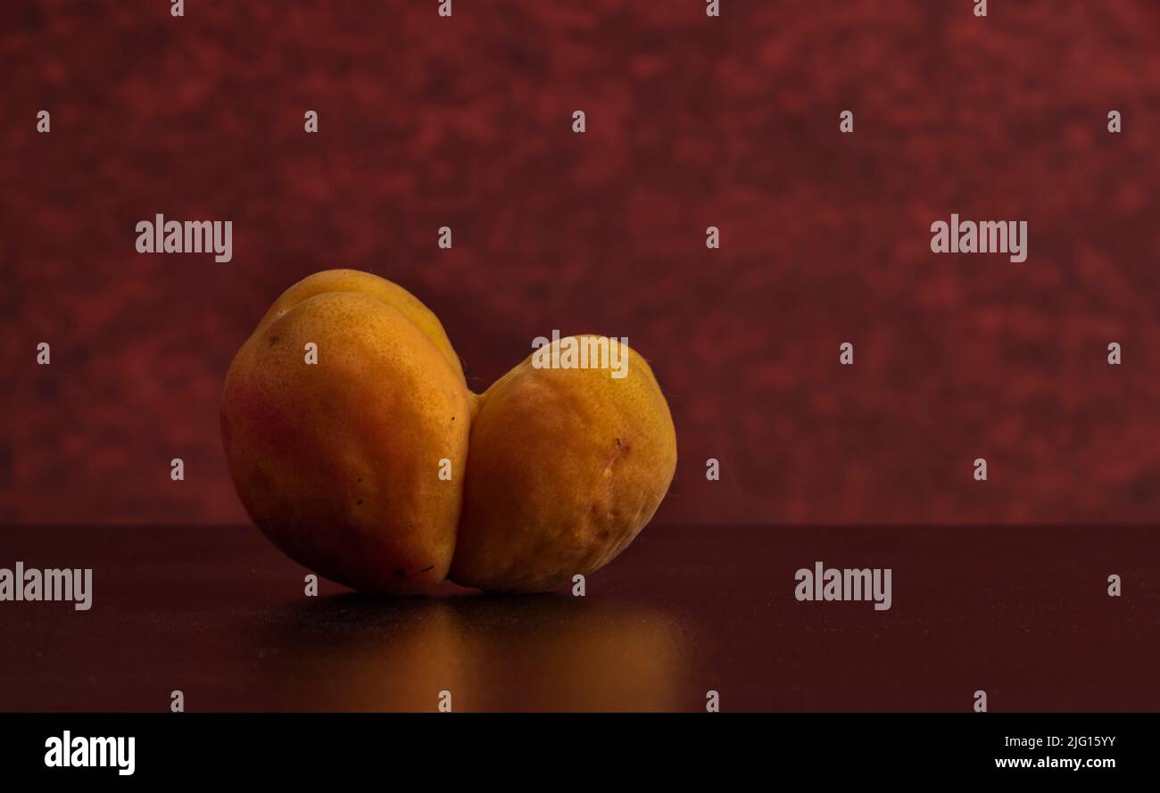 Double fresh color apricots on black table with red background Stock ...
