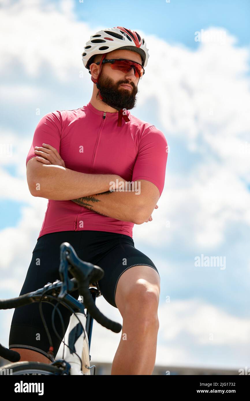 Strong Male cyclist in sportswear, glasses and protective helmet ...