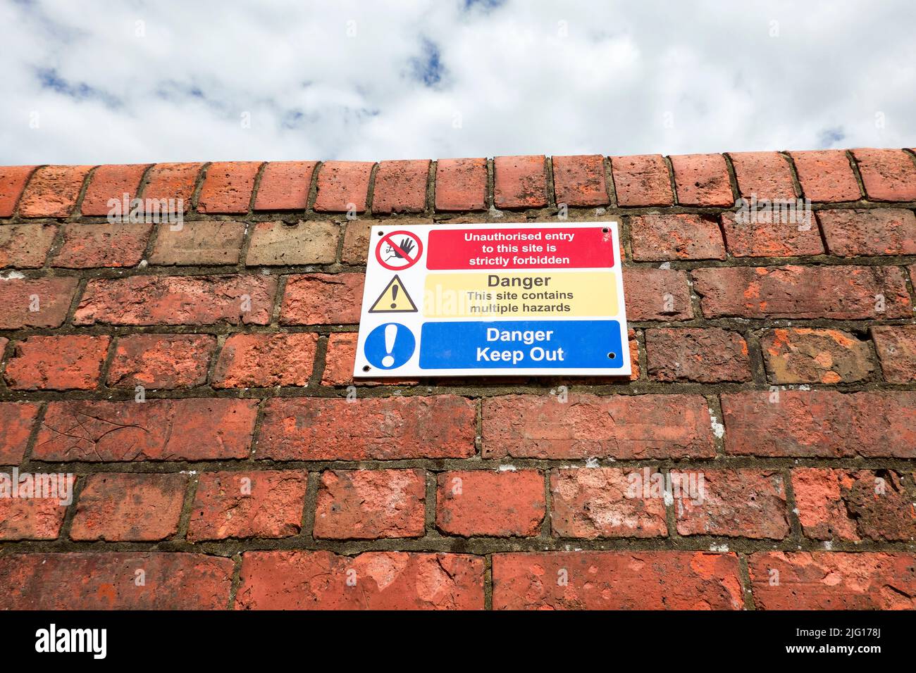 Danger keep out and hazard warning sign on red brick wall Stock Photo ...