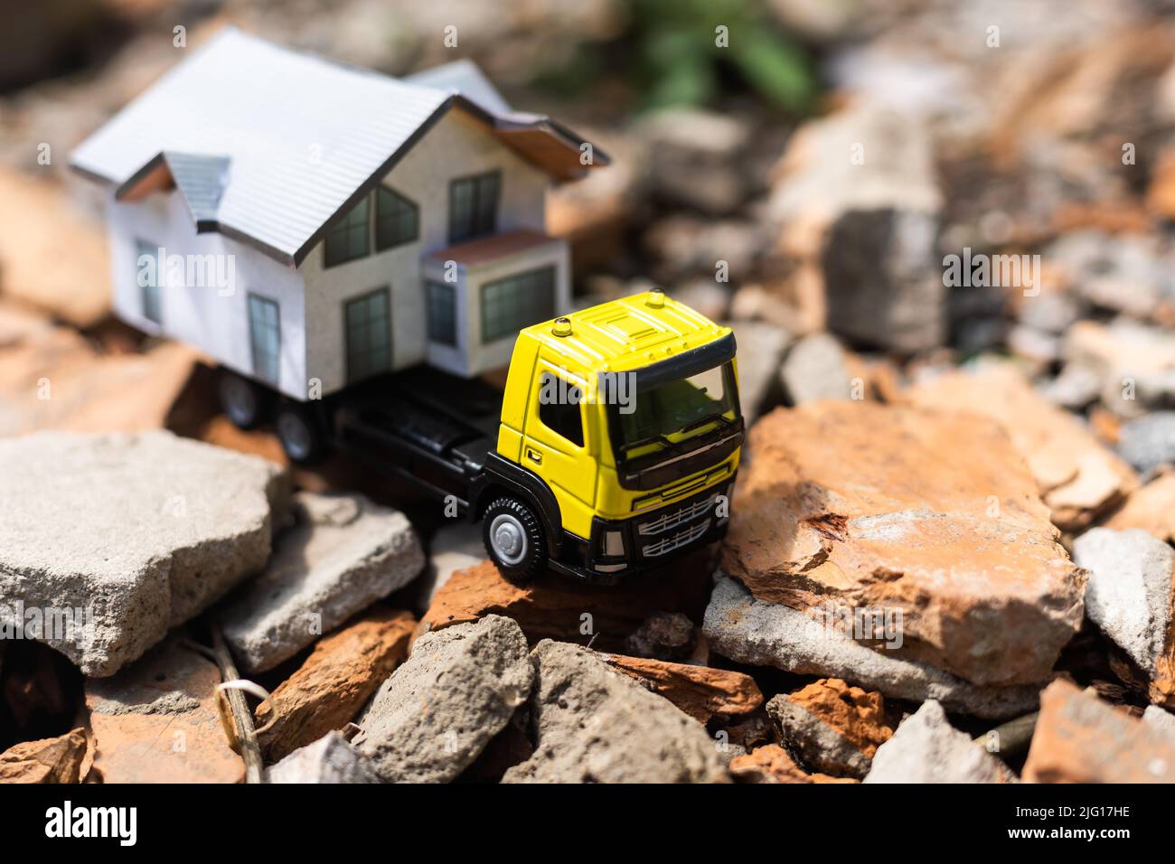 Close-up of a small toy truck on a tree stump carrying a miniature ...