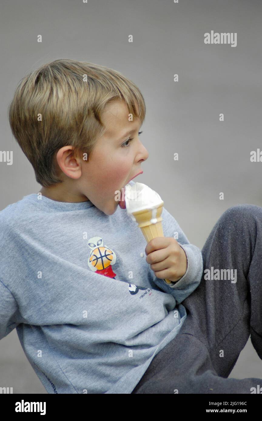 Young boy with face paint eating Ice Cream Cone soft white, with copy ...