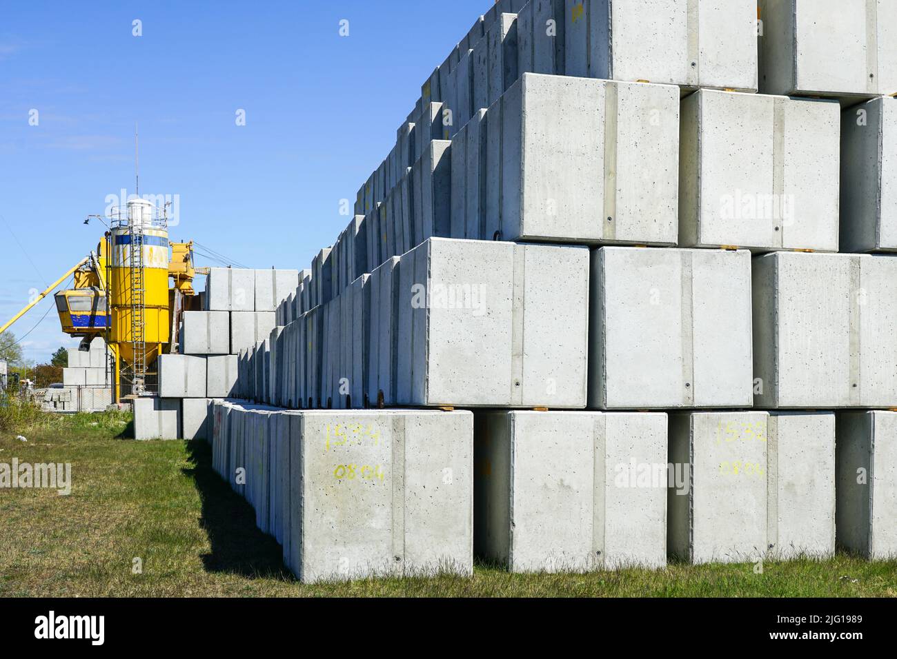 Stack of many large white concrete cube shaped blocks and yellow cement ...