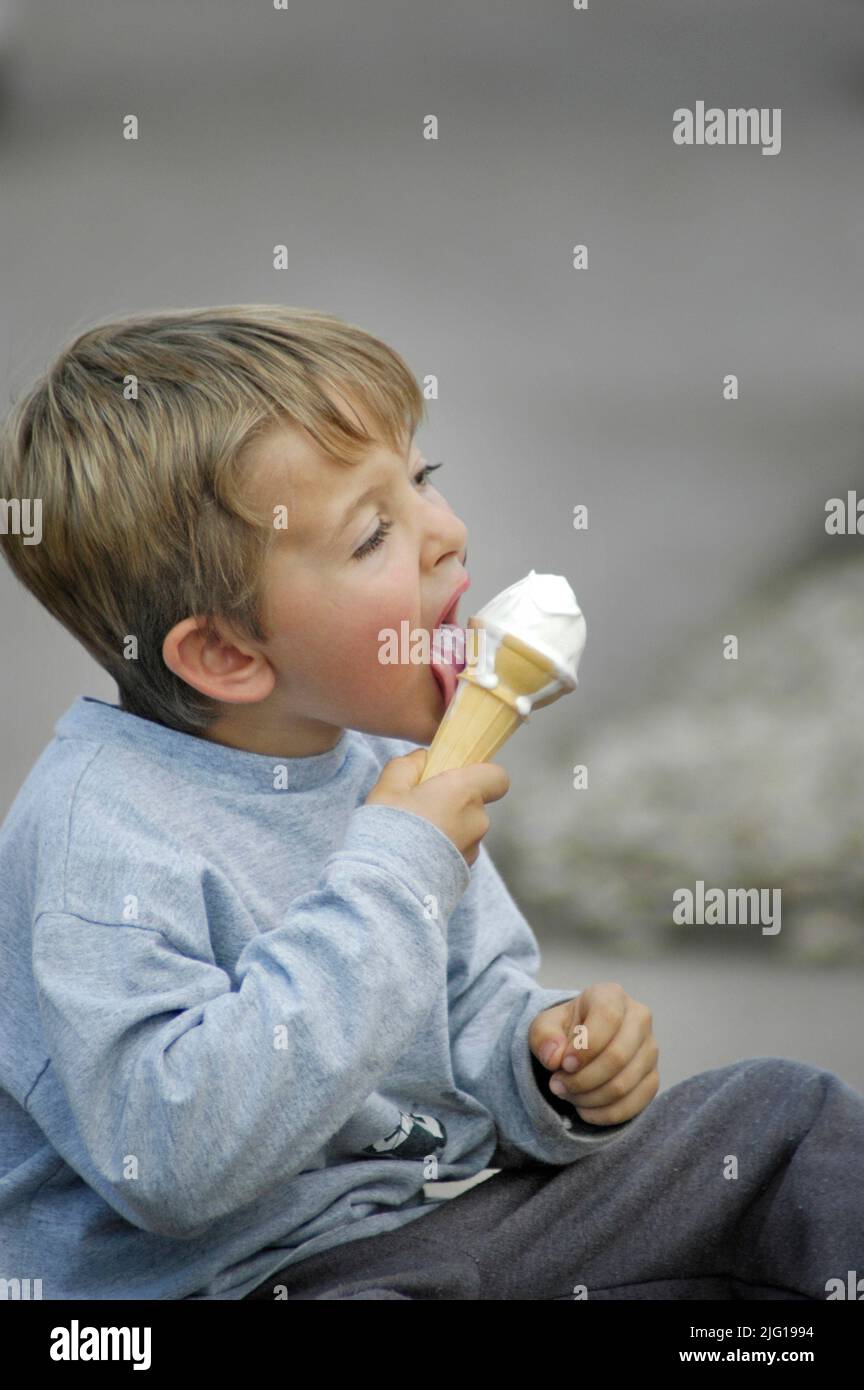 Young boy with face paint eating Ice Cream Cone soft white, with copy ...