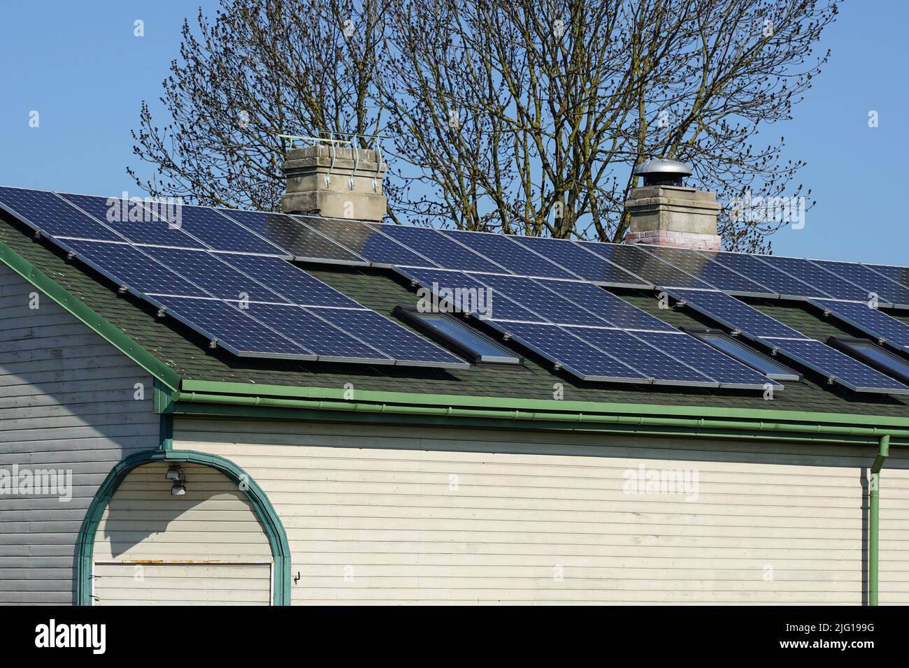 Many photovoltaic solar panels mounted on the old large wooden house ...