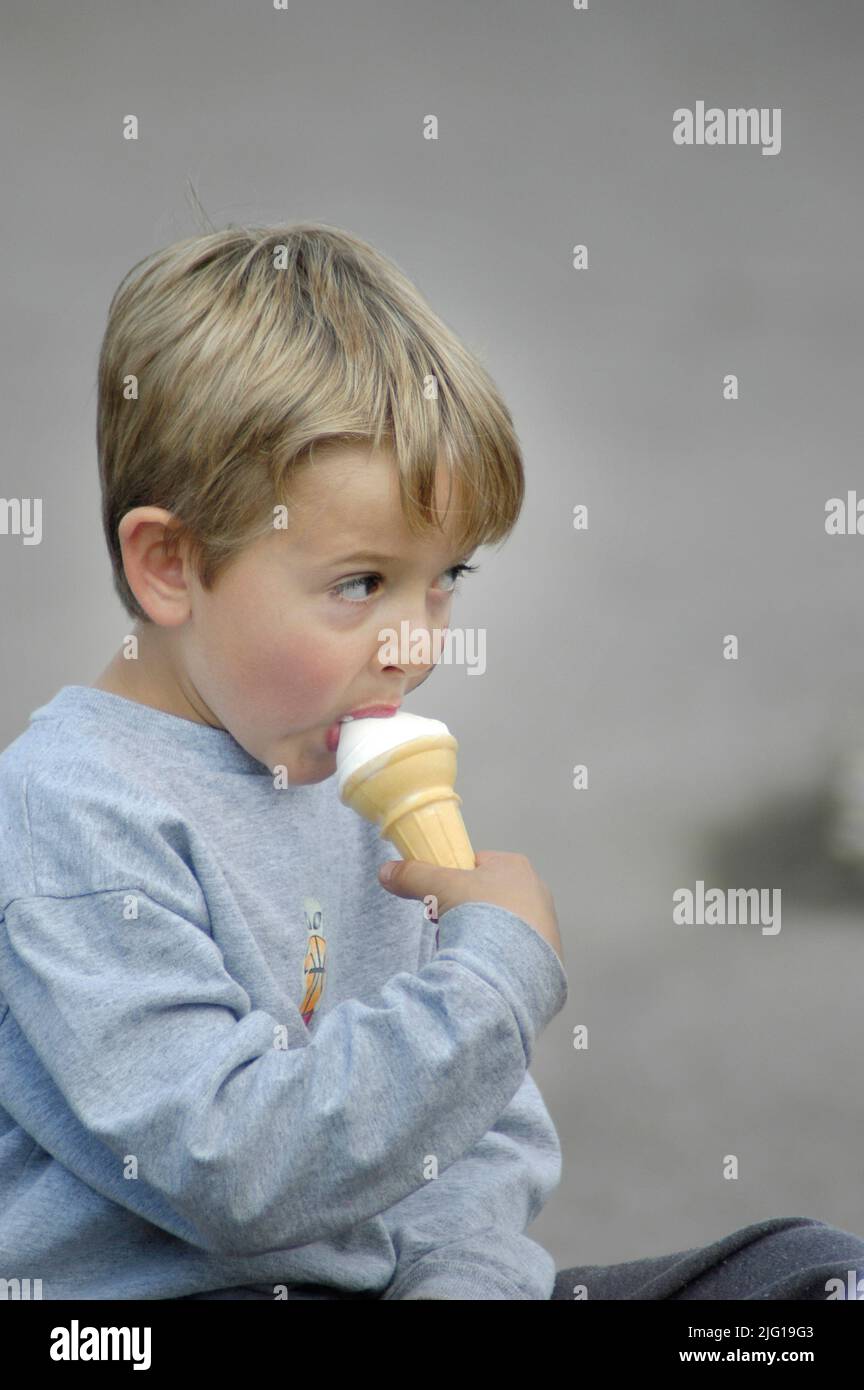 Young boy with face paint eating Ice Cream Cone soft white, with copy ...