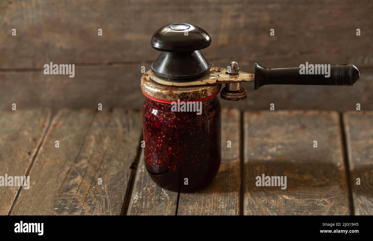 Closing the lid on a jar of raspberry jam. Preservation, cooking, food ...