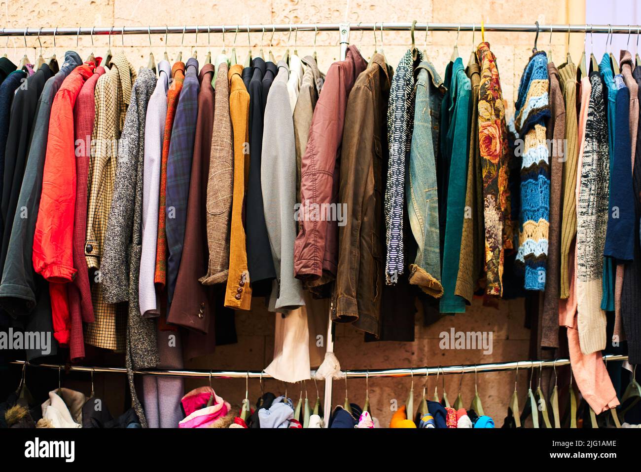 Hanger with free clothes in humanitarian centre Stock Photo - Alamy
