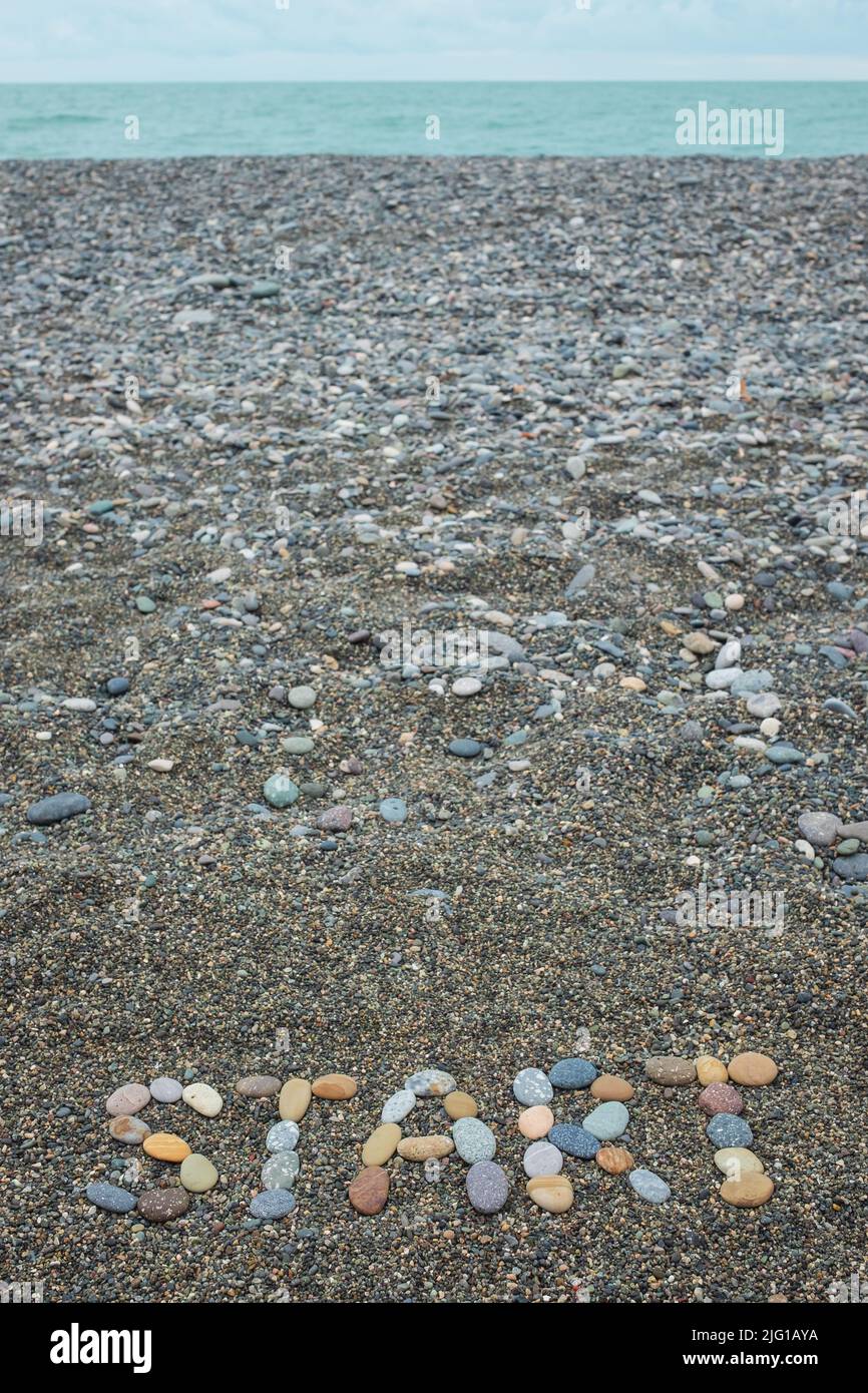 Word start made from stones on sandy beach Stock Photo - Alamy