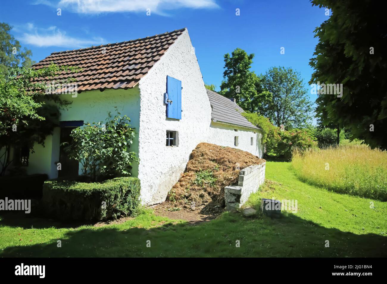 Idyllic white old german farm house, dung heap, blue summer sky, green ...