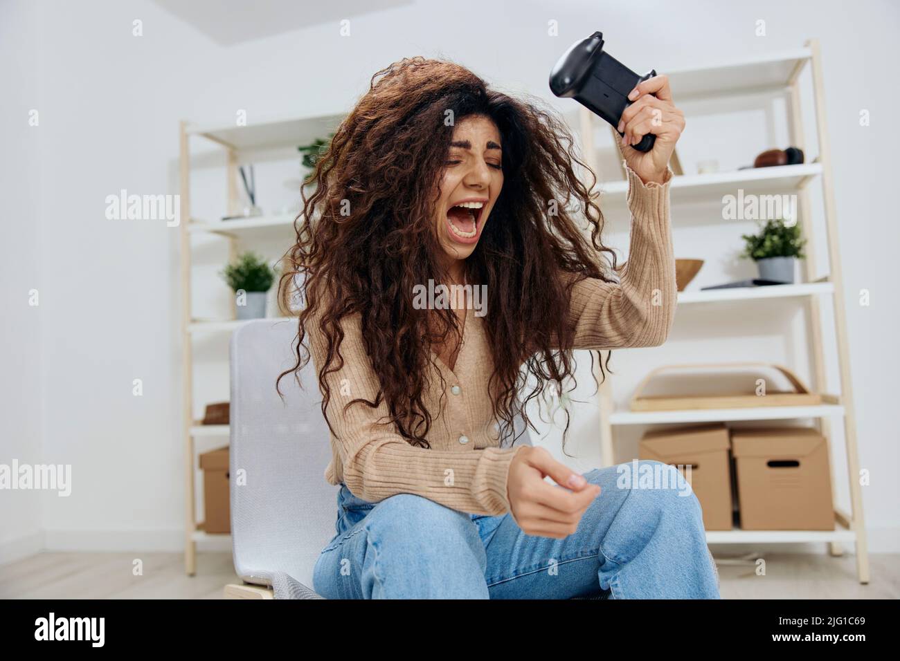 Irritated angry upset tanned curly Latin lady lose game throw joystick ...